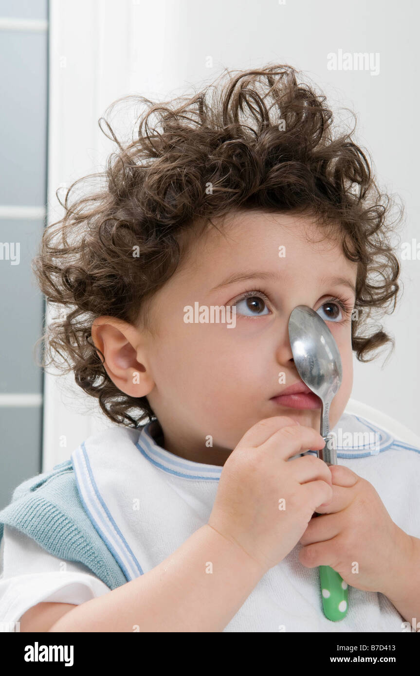 A boy holding a spoon on his nose Stock Photo - Alamy
