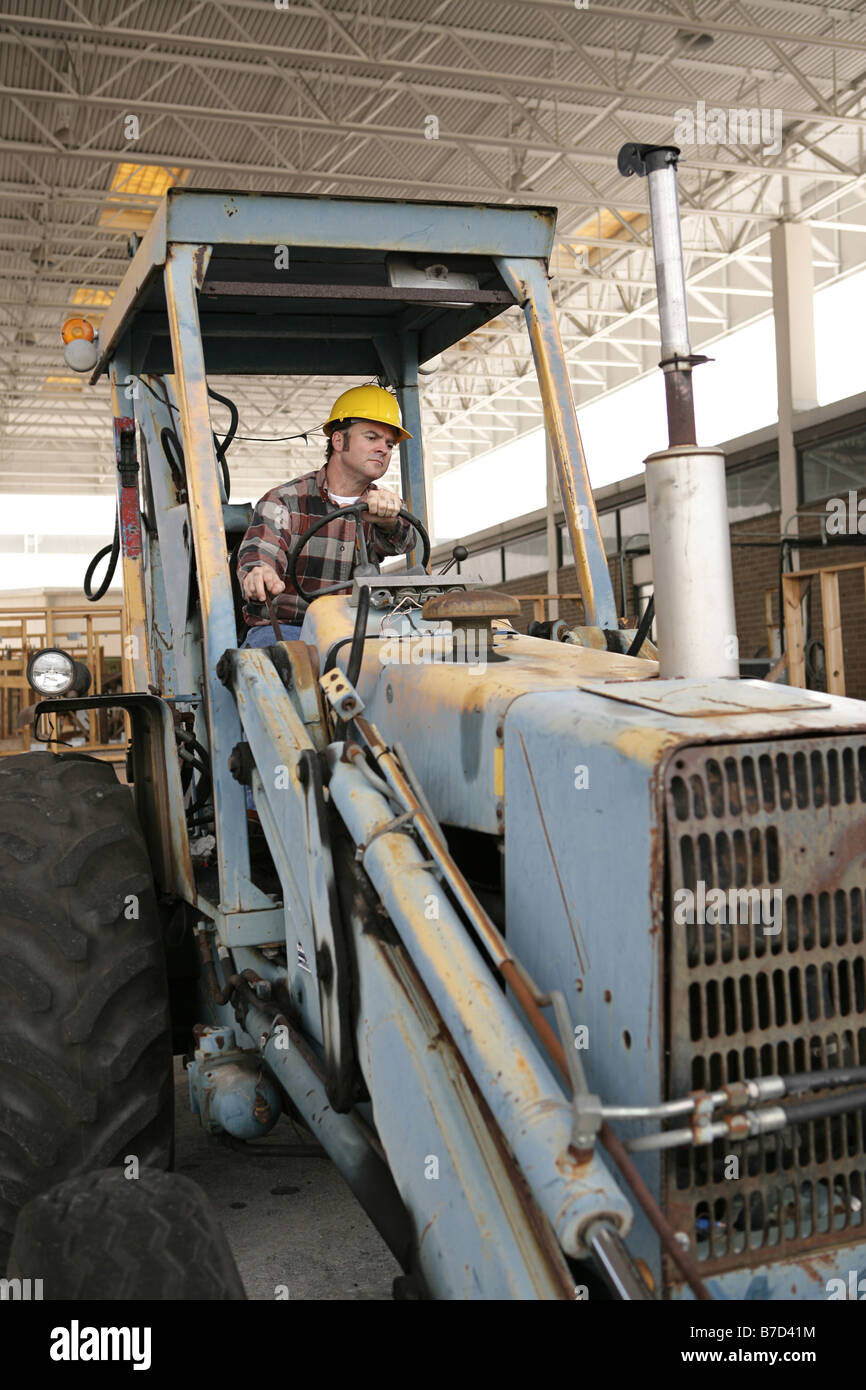 A construction worker operating a backhoe Stock Photo - Alamy