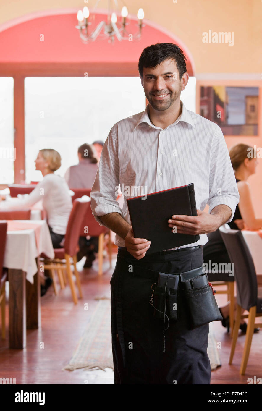 Portrait of waiter with menus in hand Stock Photo - Alamy