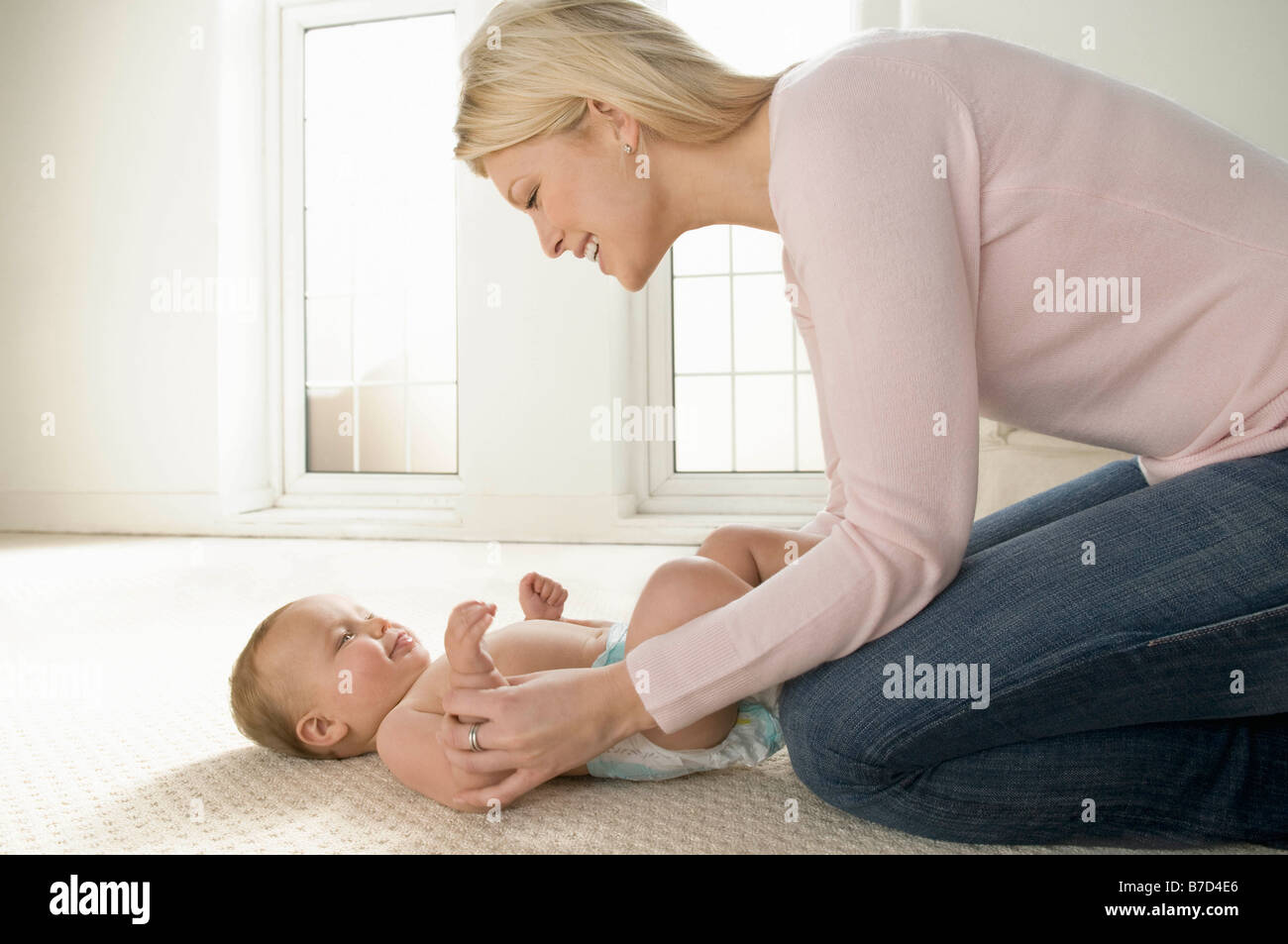 A mother smiling at her baby Stock Photo - Alamy