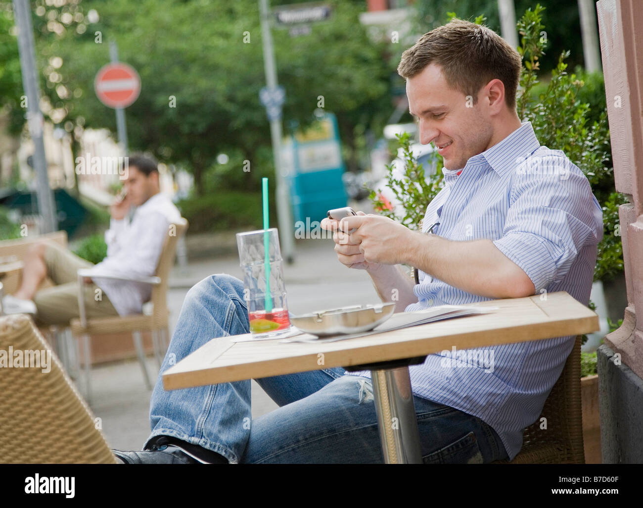 Man text messaging at table Stock Photo - Alamy