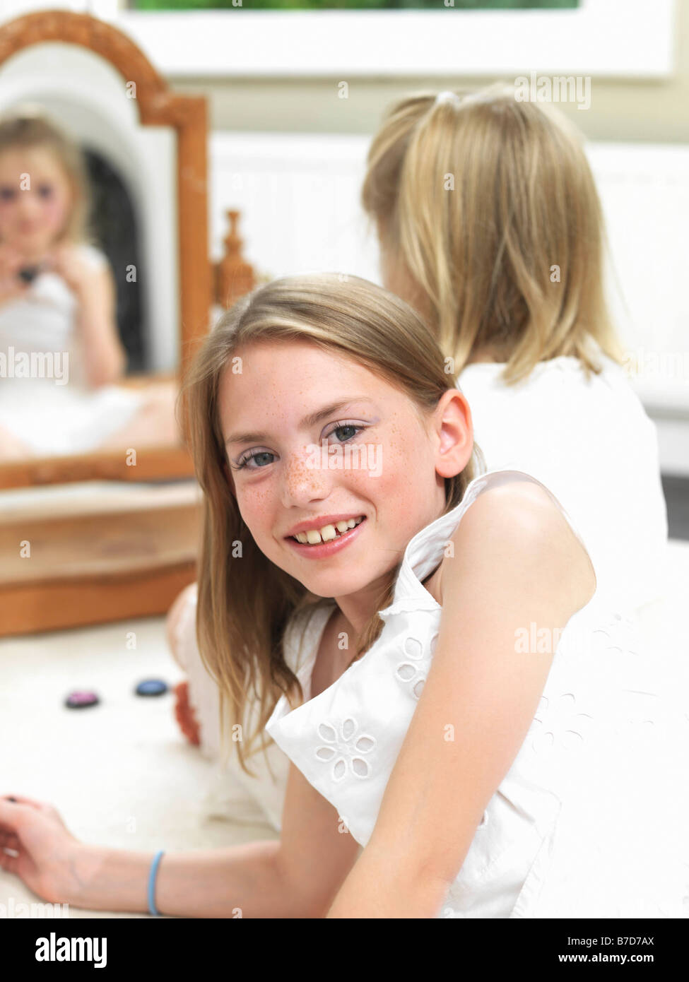 Girl smiling, mirror and girl behind Stock Photo - Alamy