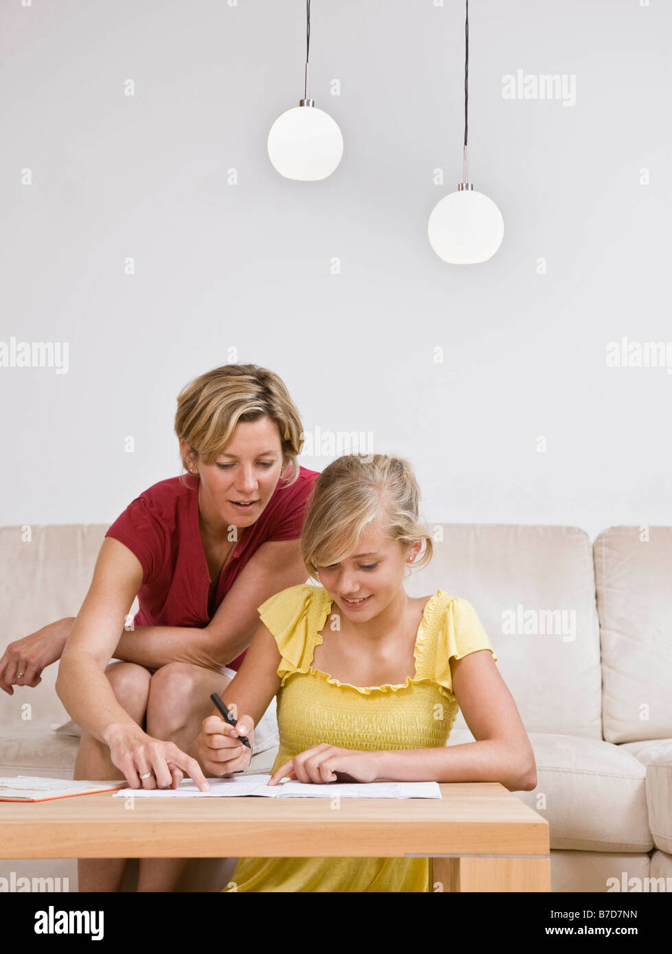 Young girl doing homework with woman Stock Photo - Alamy