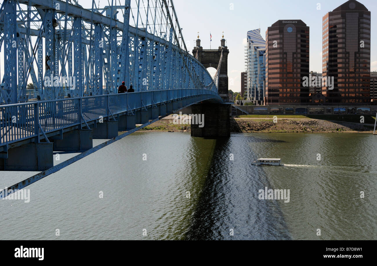 A tour boat on the Ohio River passes beneath the John A Roebling Bridge ...