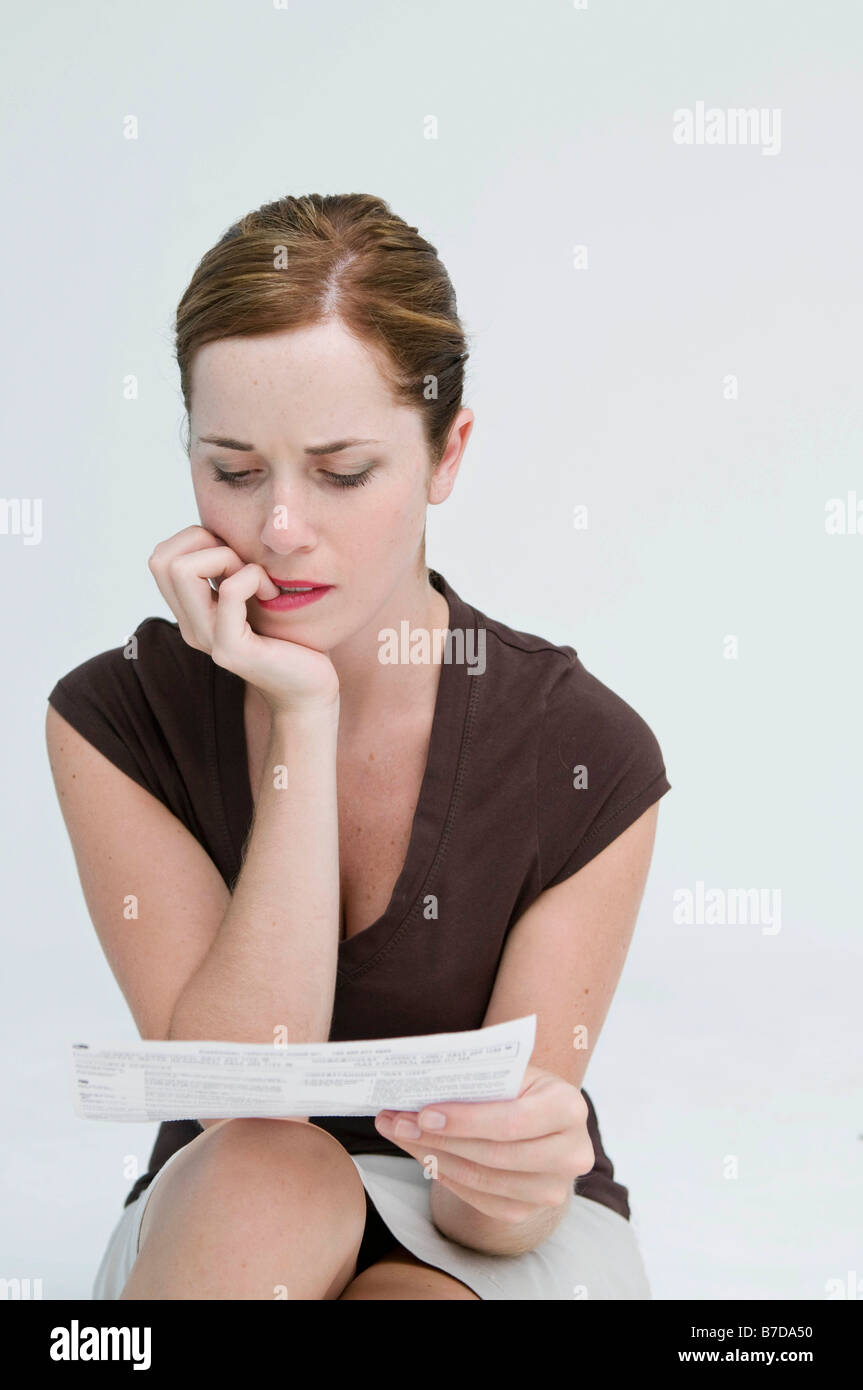 A worried woman looking at a bill Stock Photo - Alamy