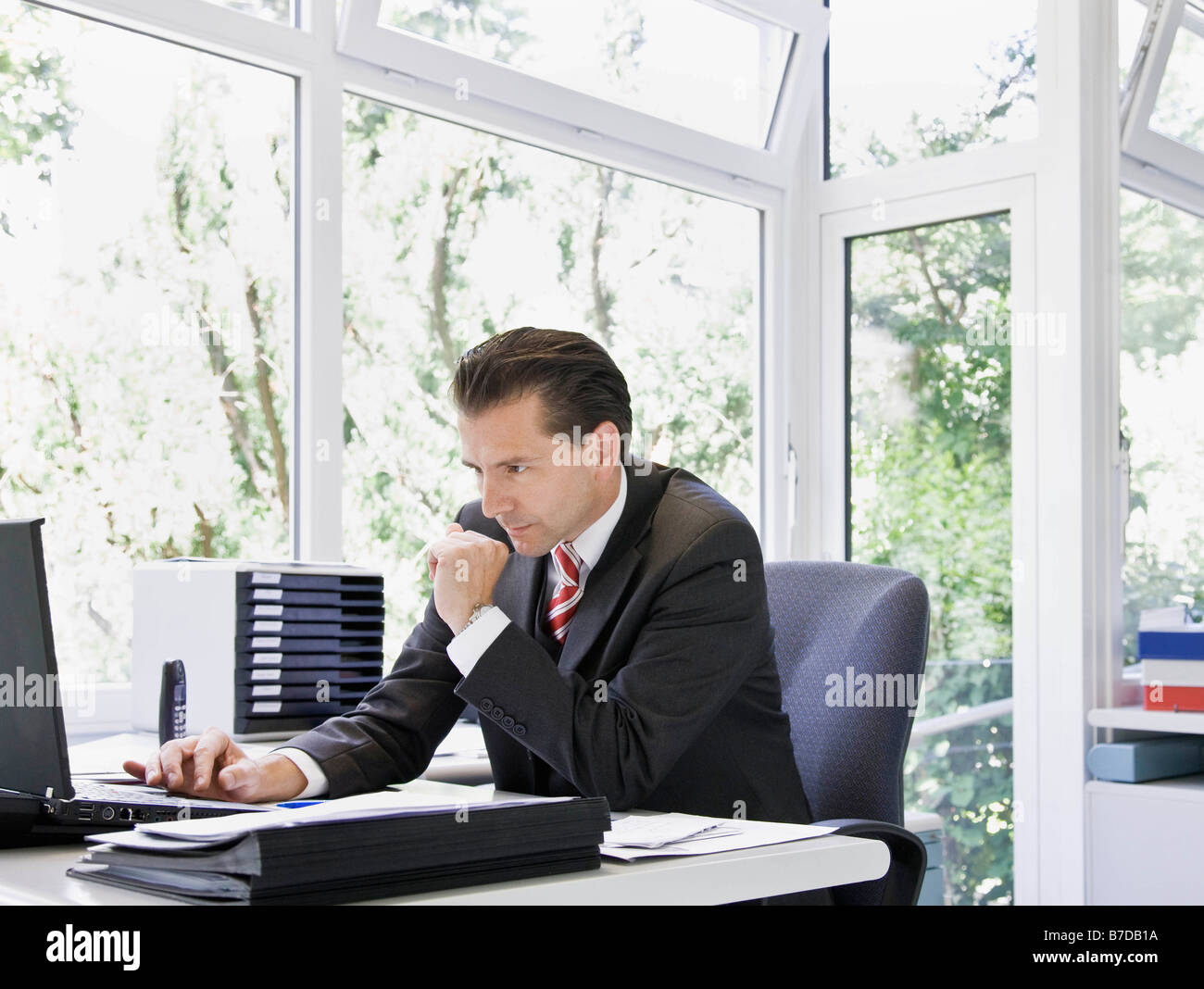 Determined man looking at laptop Stock Photo - Alamy