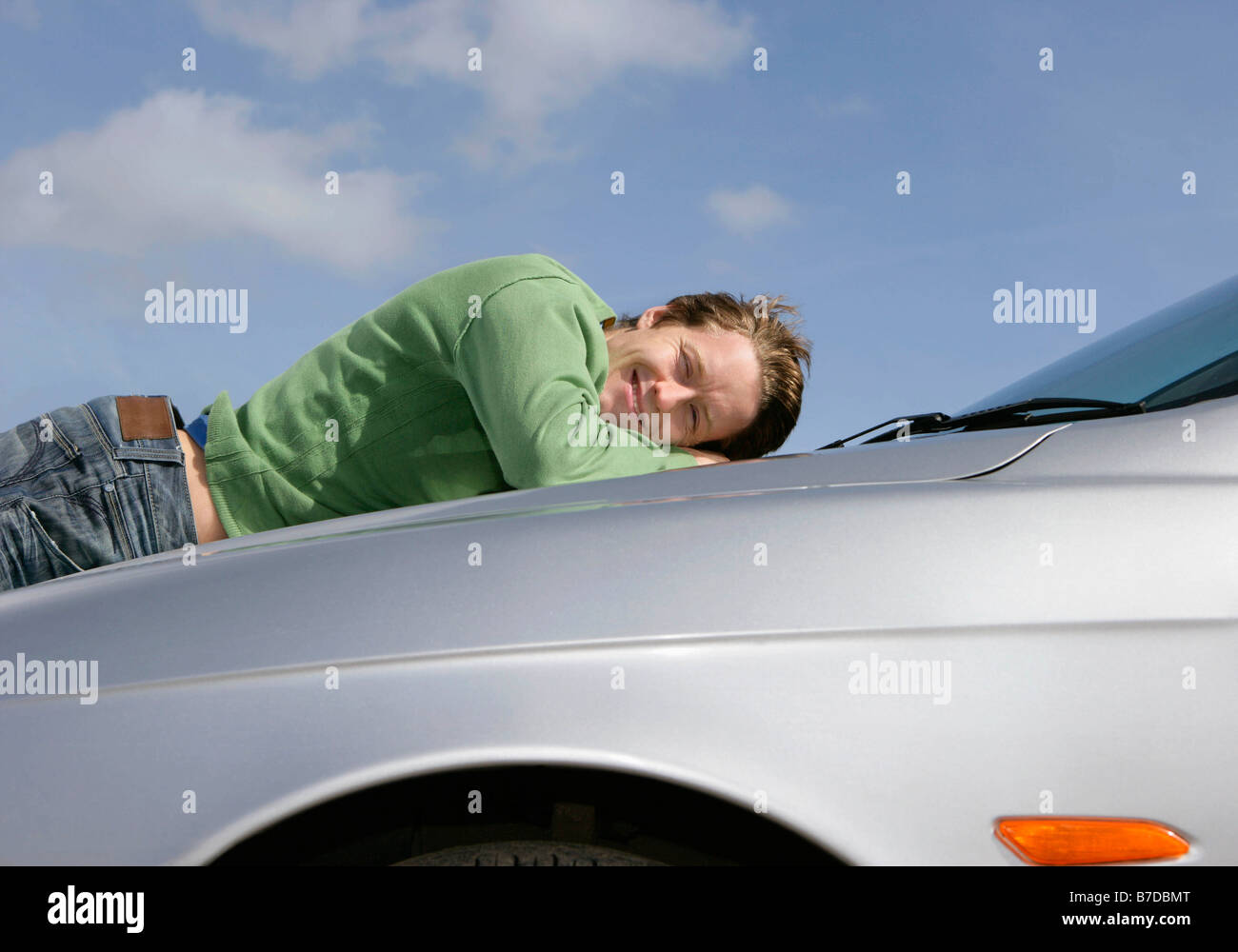 Man lying on car Stock Photo - Alamy