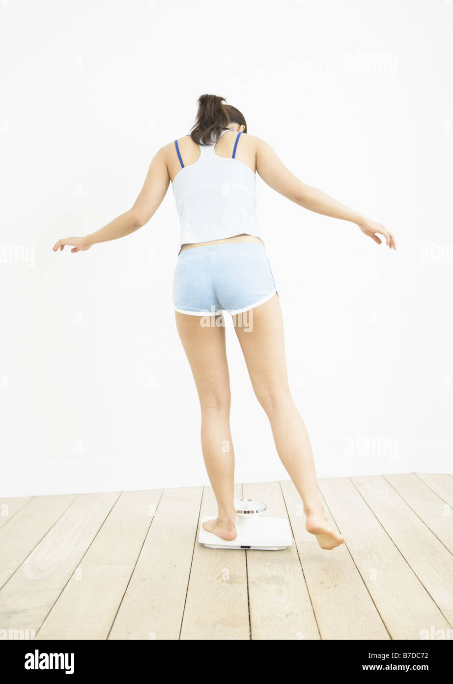 Woman getting on the scale Stock Photo - Alamy