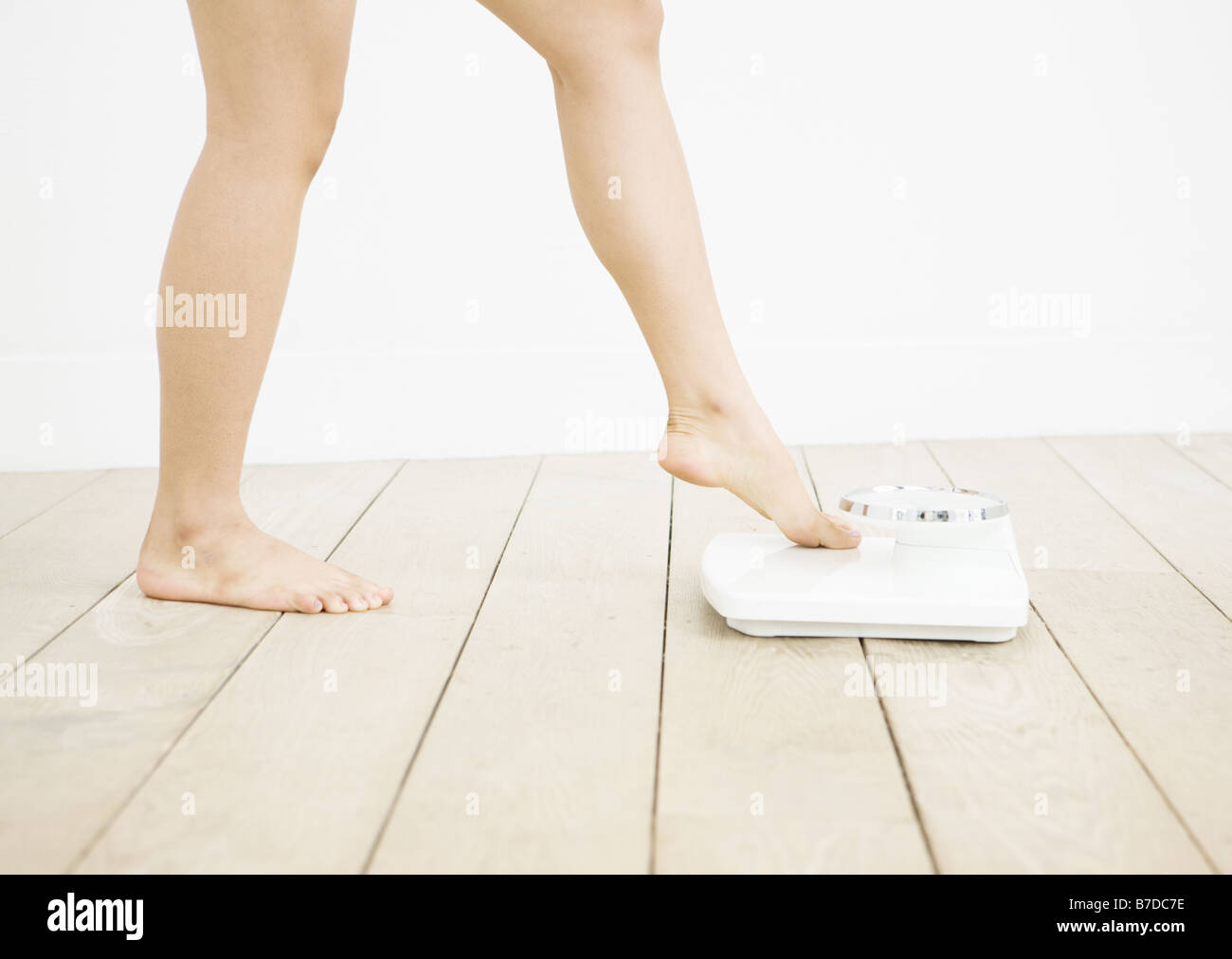 Woman getting on the scale Stock Photo - Alamy