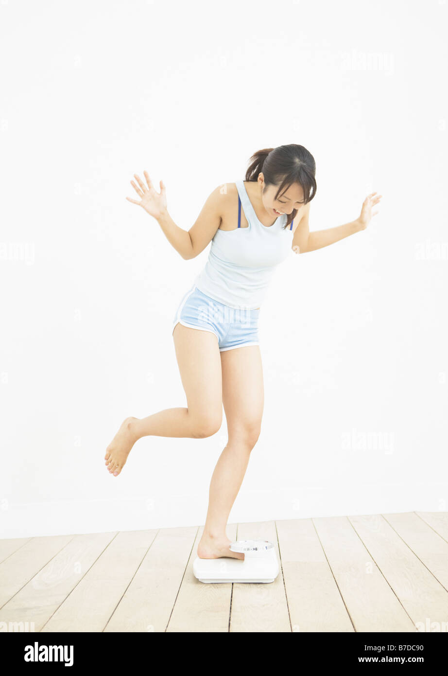 Woman getting on the scale Stock Photo - Alamy