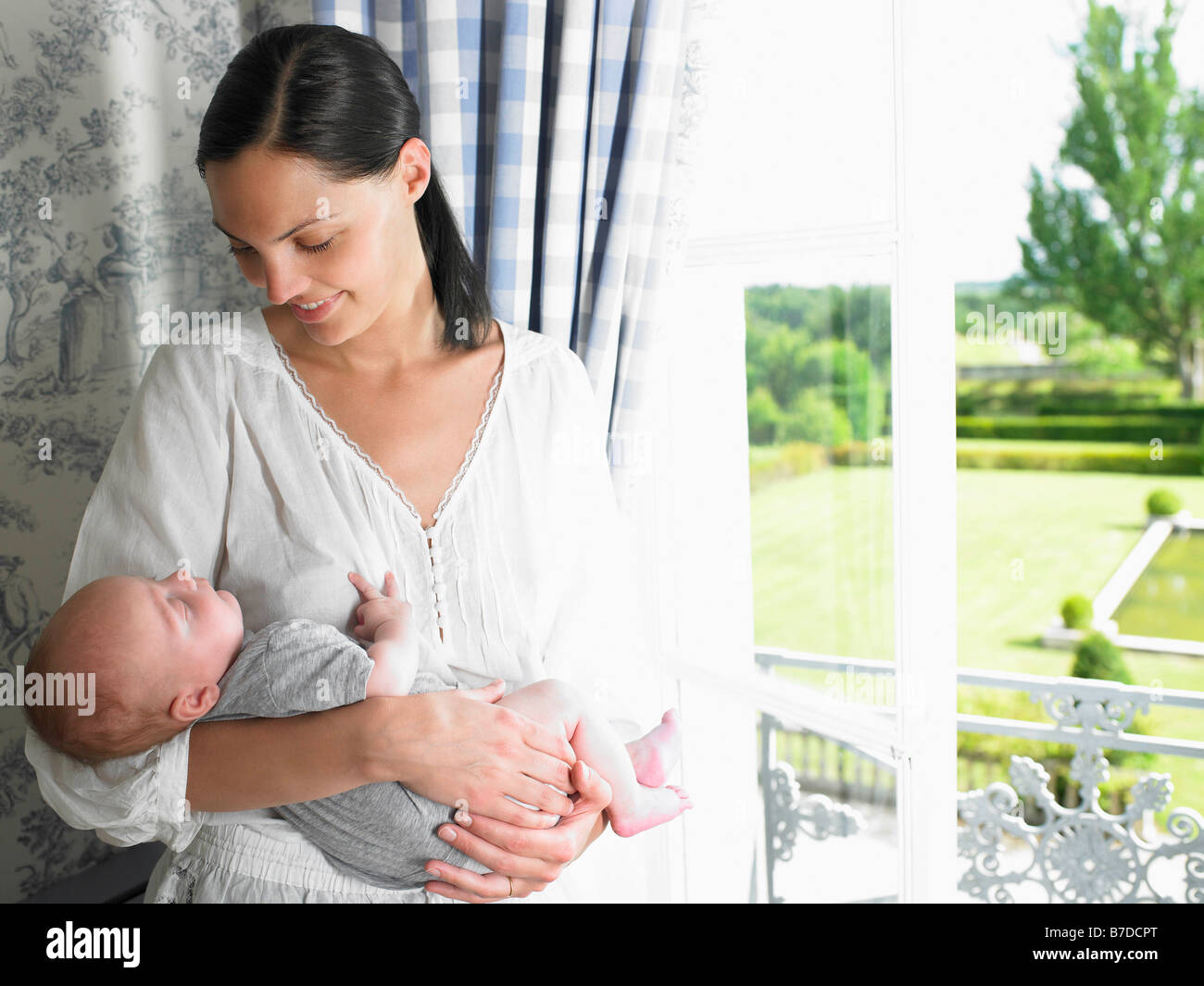 Mother and baby by the window Stock Photo - Alamy