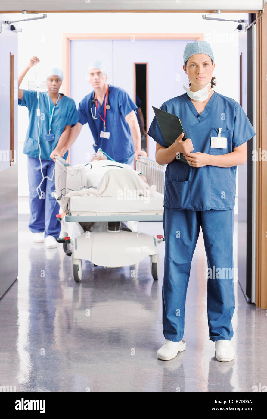 Three doctors pushing a patient in bed Stock Photo - Alamy