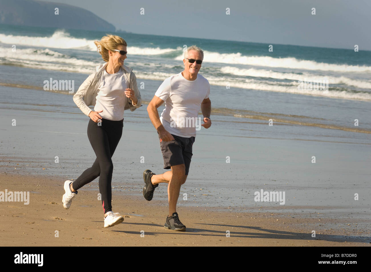 Couple running on a beach Stock Photo - Alamy