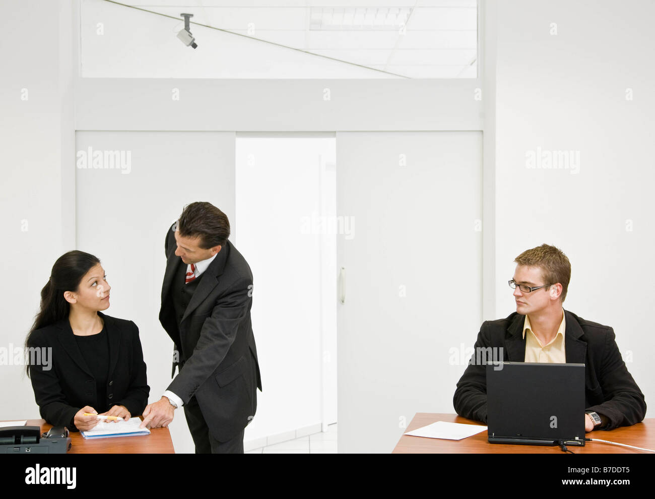 Boss helping co-workers Stock Photo - Alamy