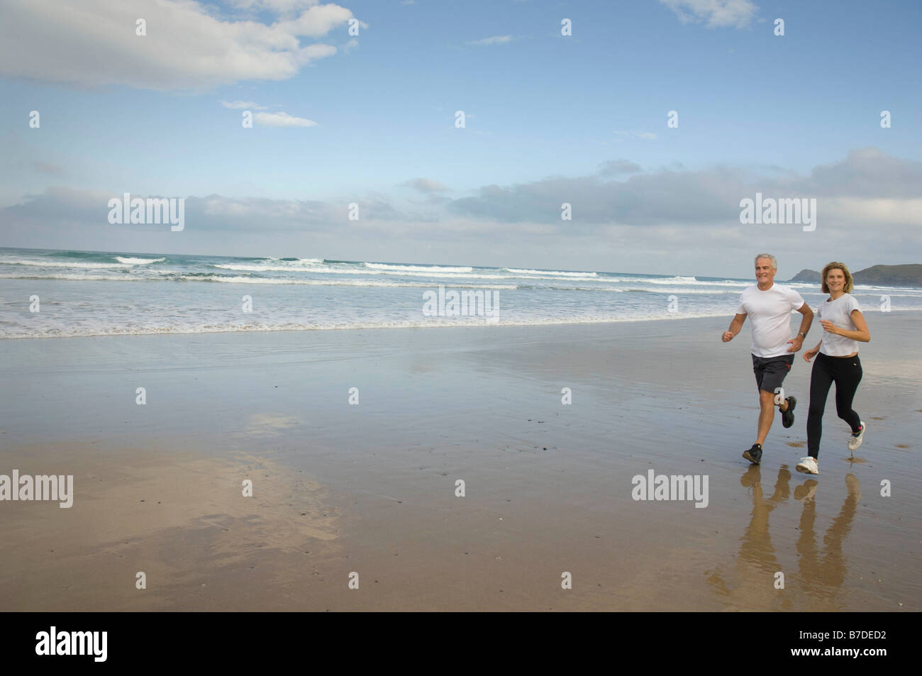 Couple running on a beach Stock Photo - Alamy
