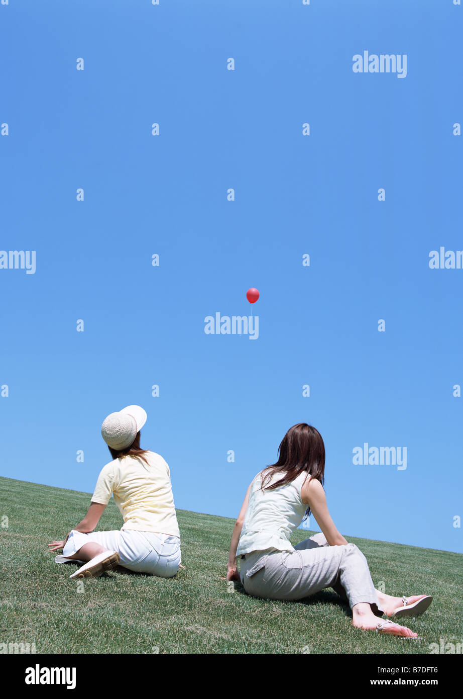 Women sitting in field Stock Photo - Alamy