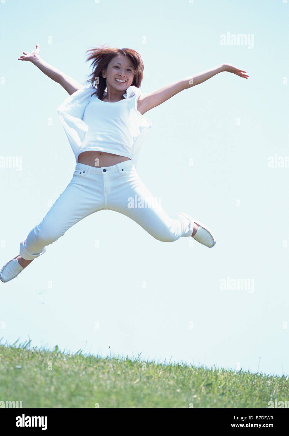 Woman jumping up in field Stock Photo - Alamy