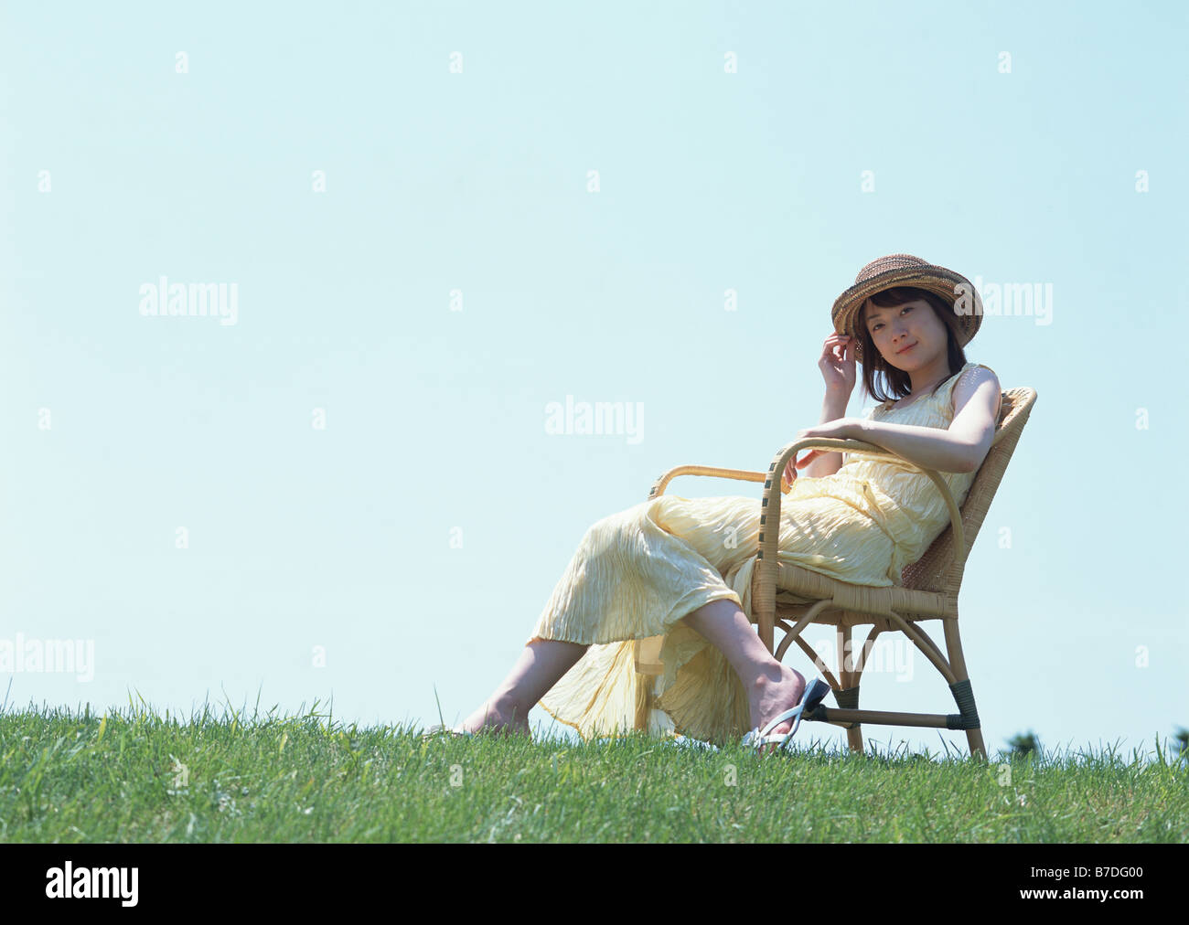 Woman sitting in field Stock Photo - Alamy
