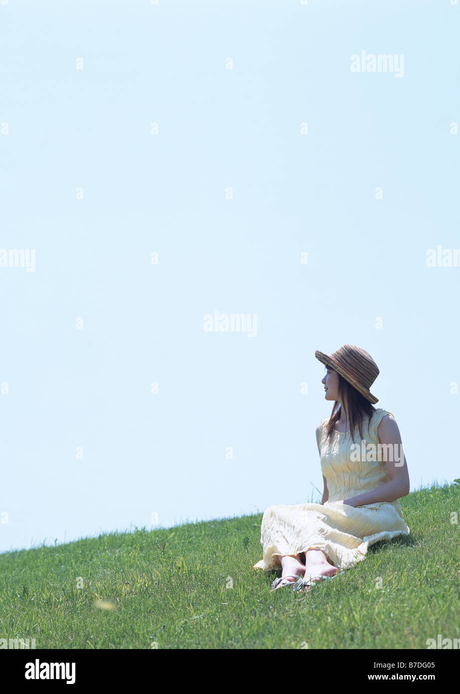 Woman sitting in field Stock Photo - Alamy