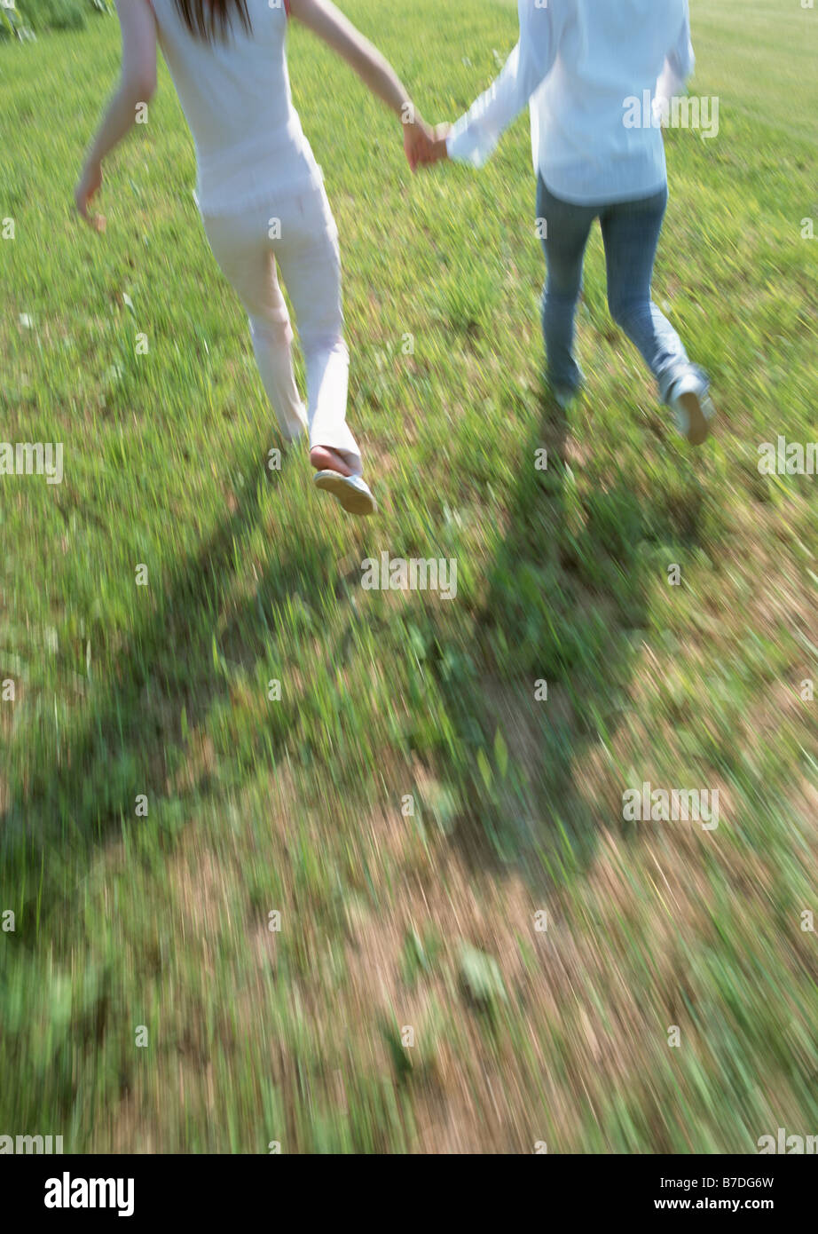 Women running hand in hand Stock Photo - Alamy