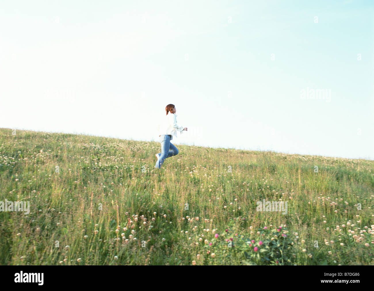 Woman running in field Stock Photo - Alamy