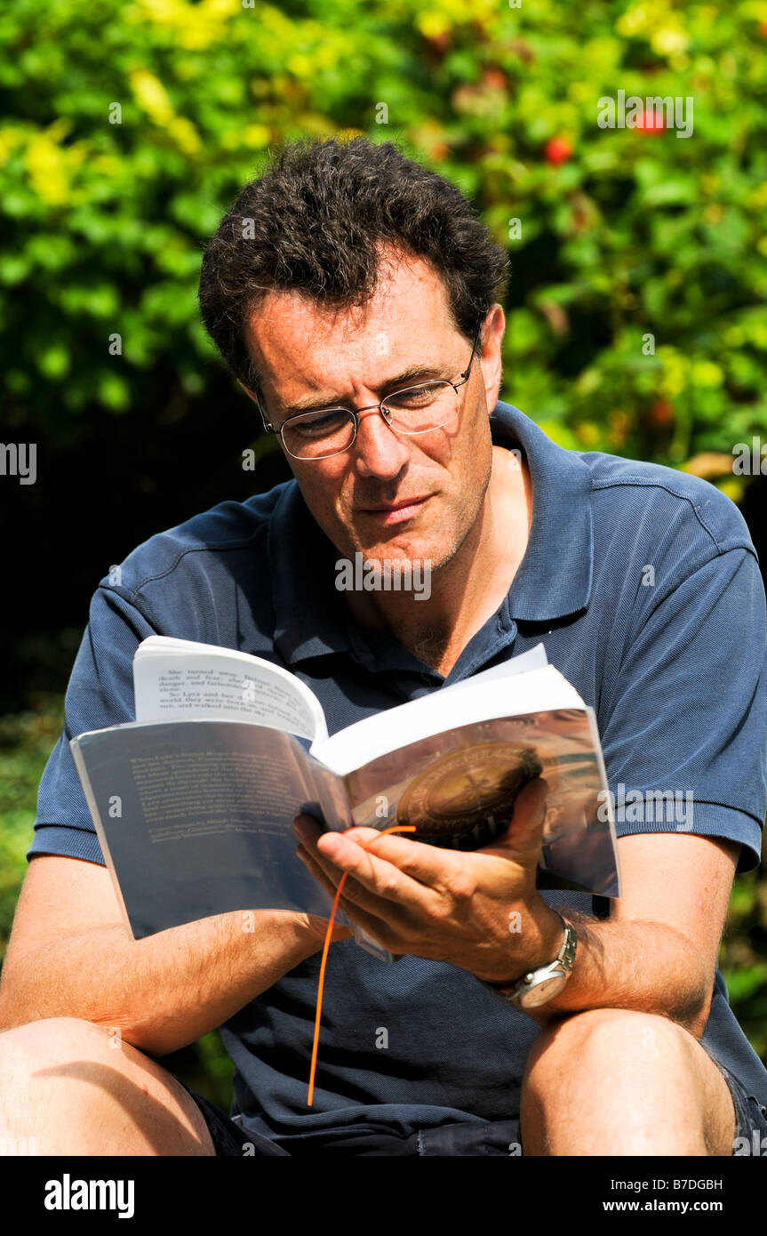 man reading book outside Stock Photo - Alamy