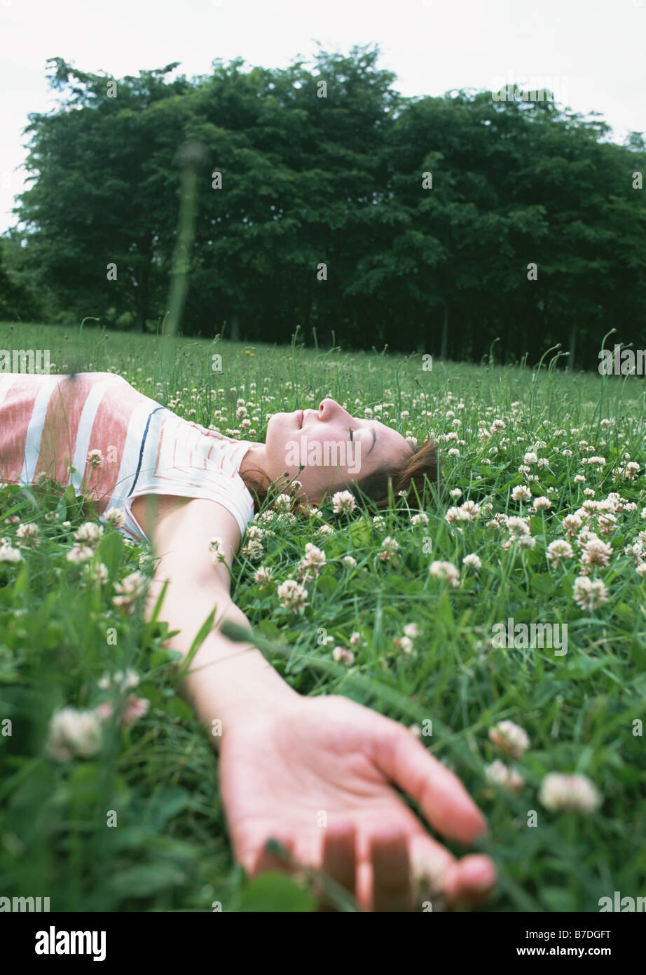 Young woman lying in field Stock Photo - Alamy