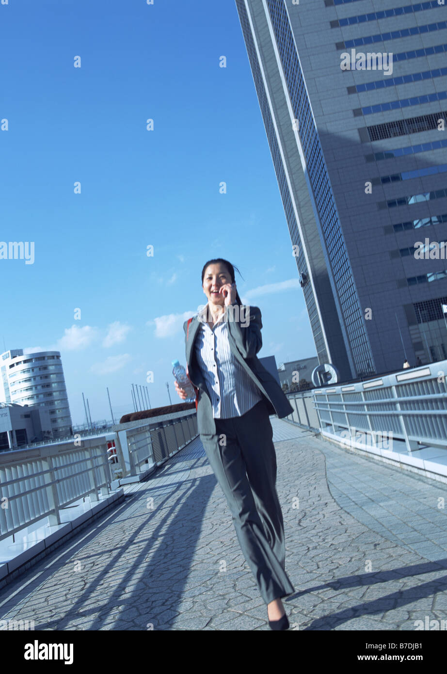 Business woman on cell-phone in rush Stock Photo - Alamy