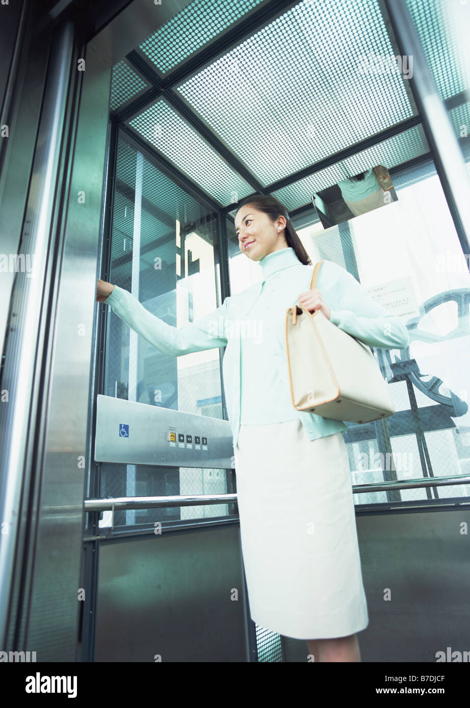 Business woman taking elevator Stock Photo - Alamy