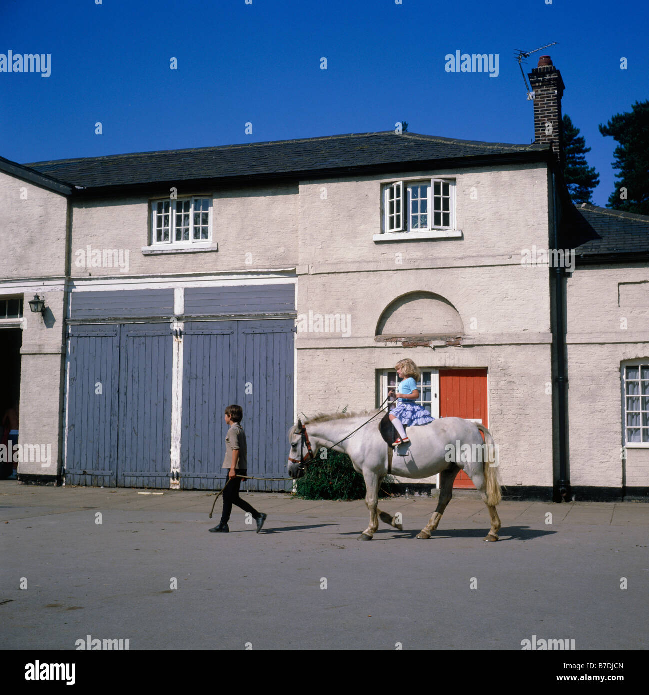 Normanby Hall country park Stable block Child on grey pony being led by ...