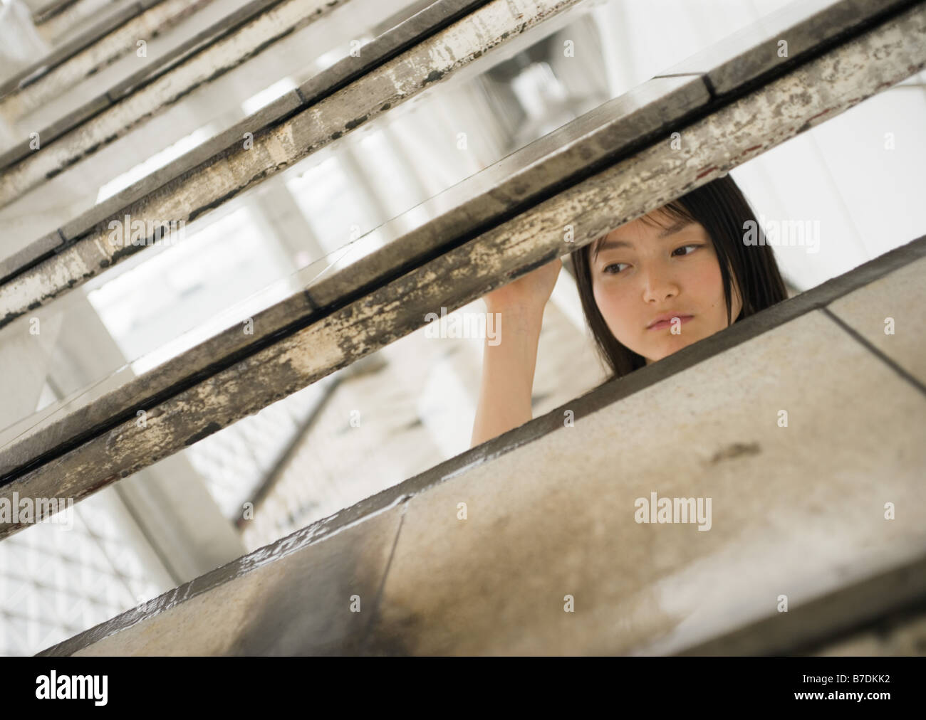 Woman peeking through stairs Stock Photo - Alamy