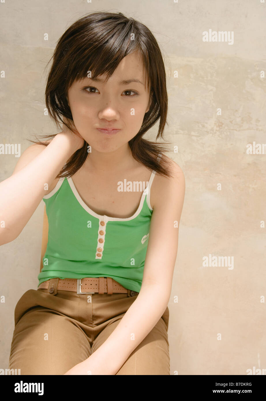 Young woman sitting on chair Stock Photo - Alamy