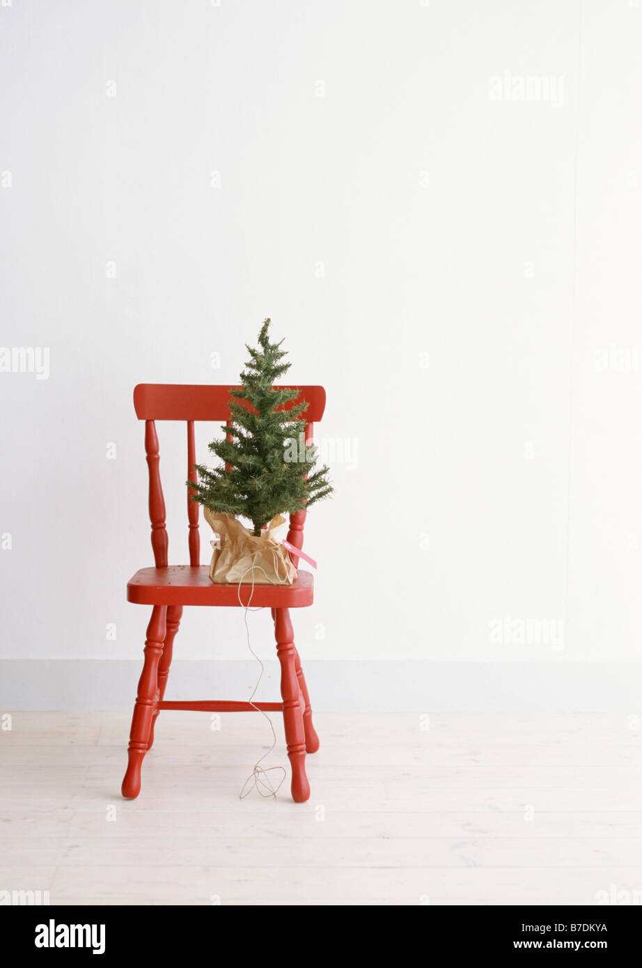 Small Christmas tree on chair Stock Photo - Alamy