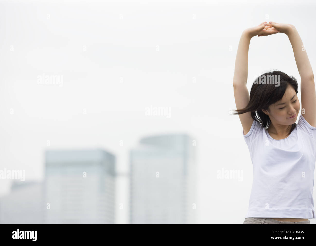 Young woman stretching arms above head Stock Photo - Alamy