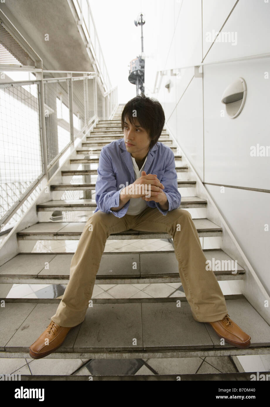Man sitting on stairs Stock Photo - Alamy