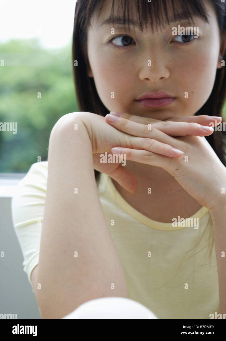 Young woman resting chin on hand Stock Photo - Alamy