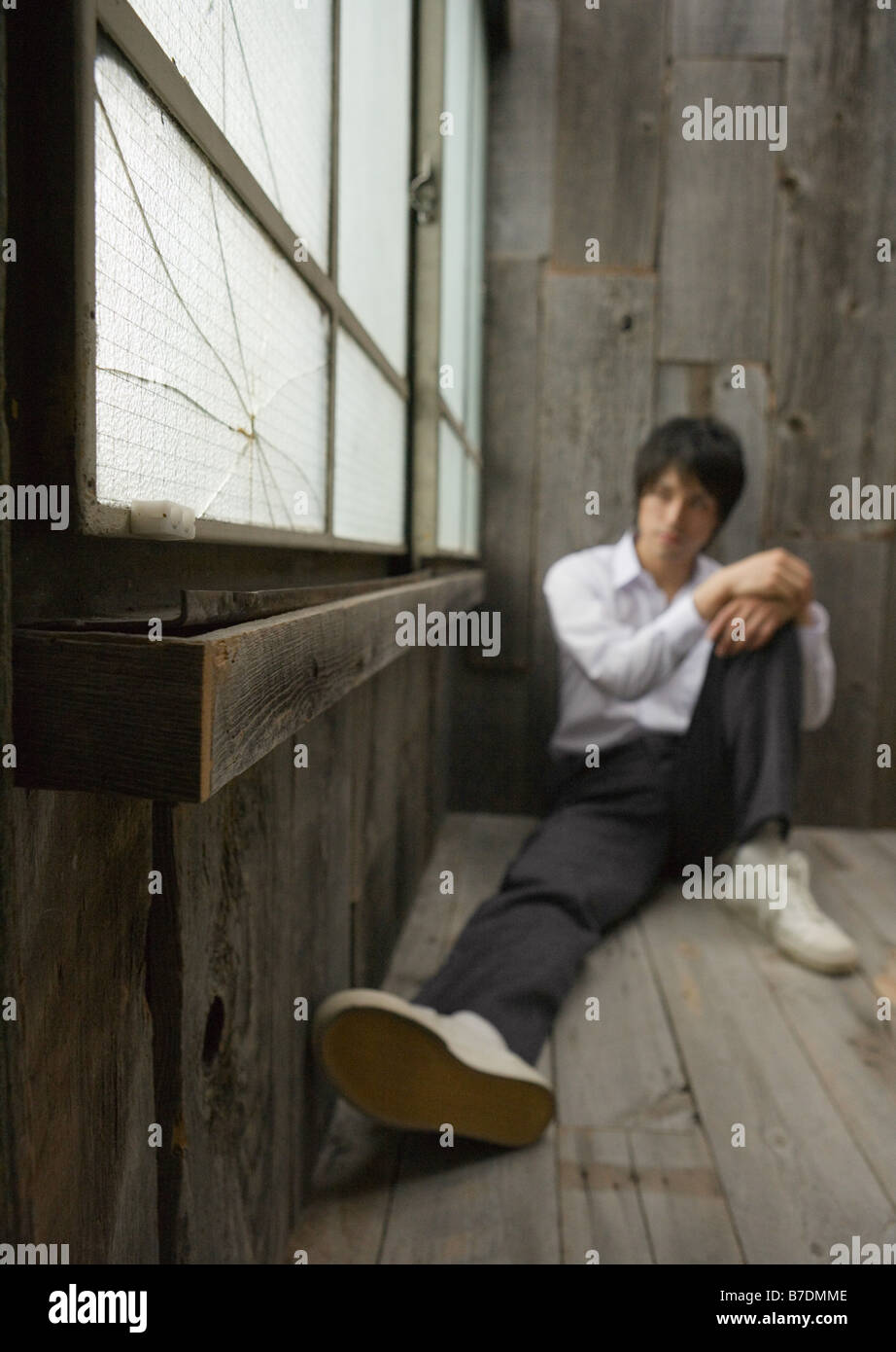 Man sitting by window in school uniform Stock Photo - Alamy