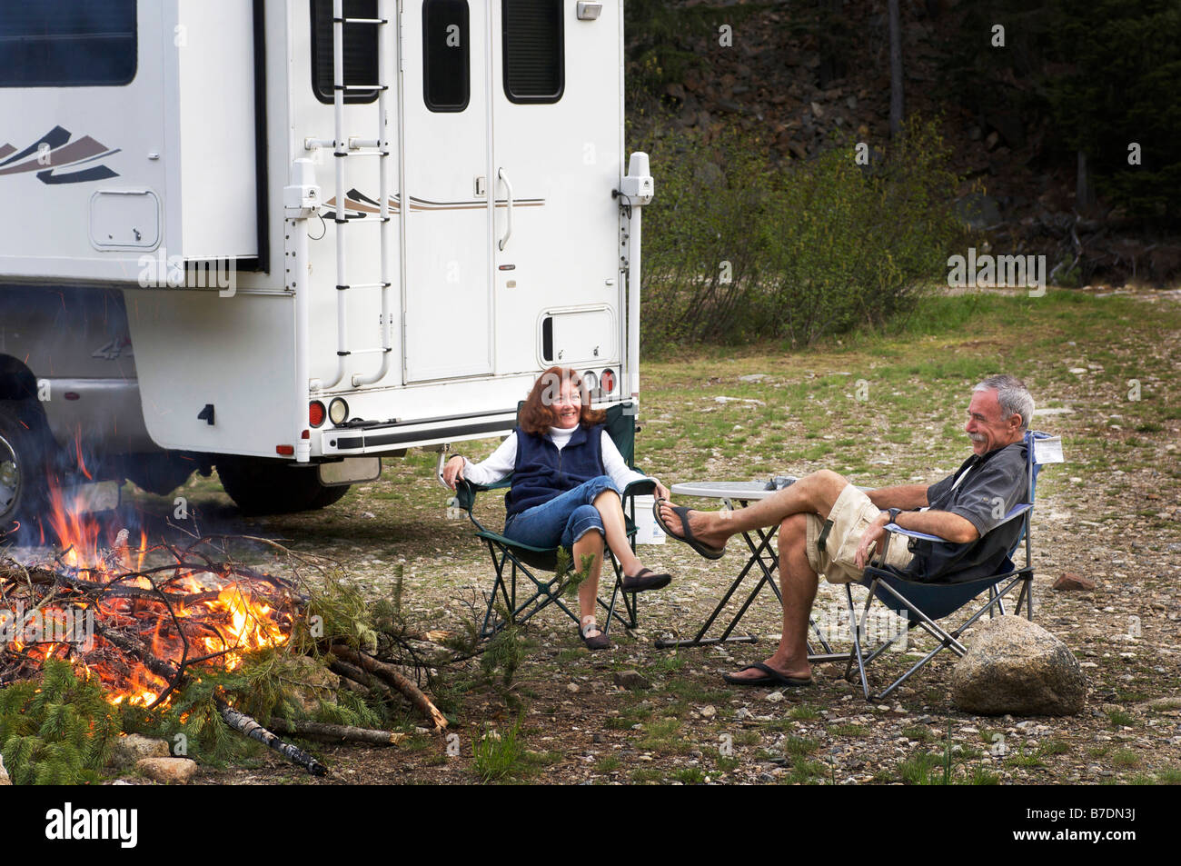 A couple enjoys a fire by their camper Near Duffy lake on the Sea to ...