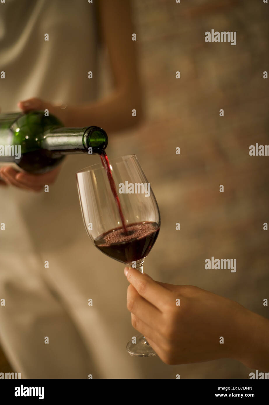 Woman pouring red wine Stock Photo - Alamy