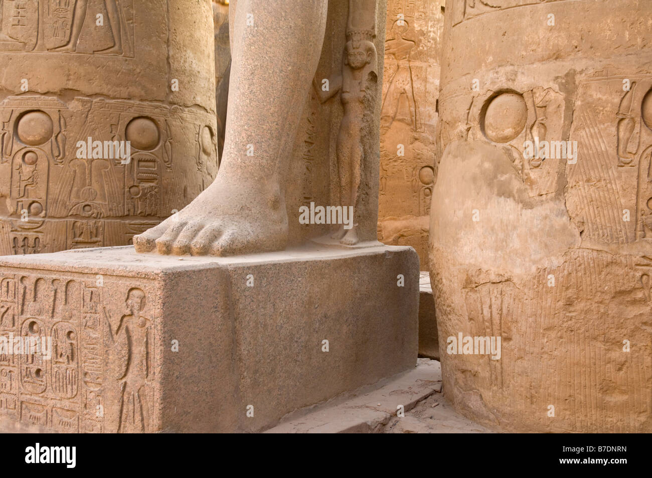 Foot of giant statue and columns covered with hieroglyphics inside the ...