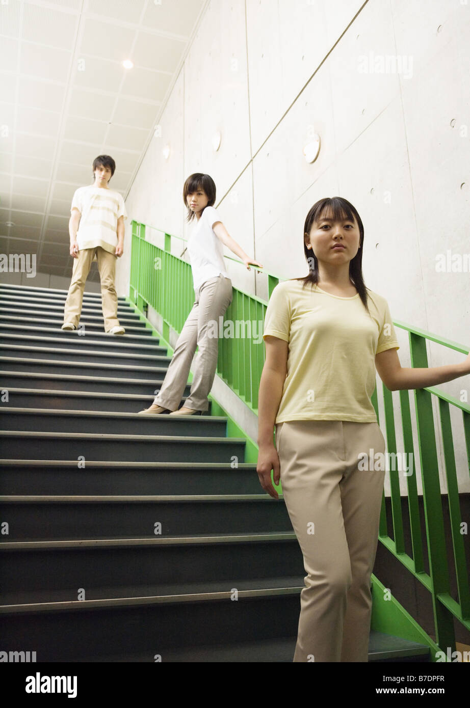 Young people standing on stairs Stock Photo - Alamy