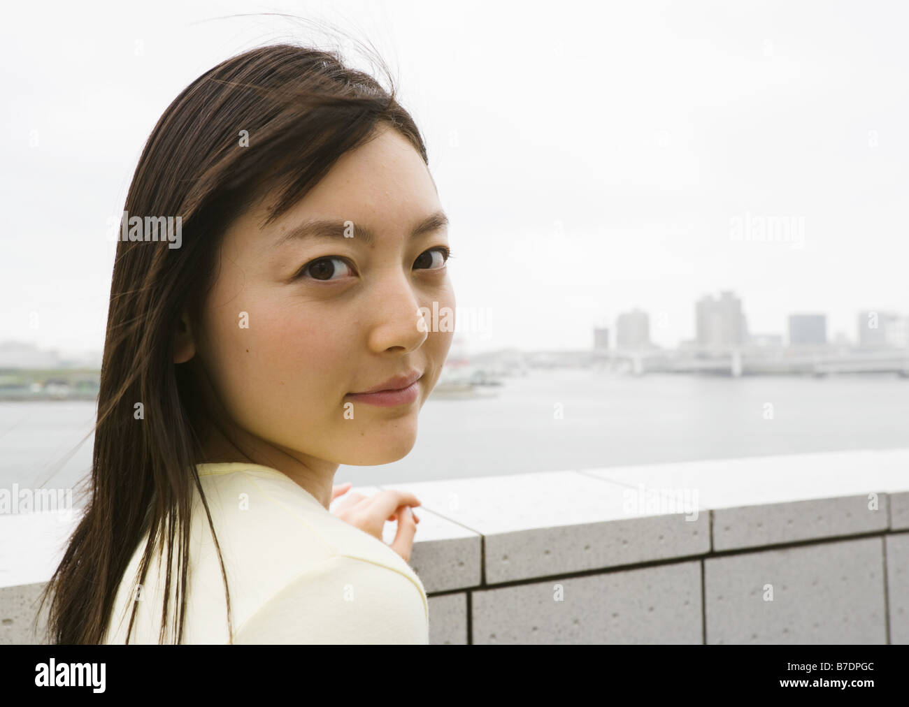 Young woman looking over shoulder Stock Photo - Alamy