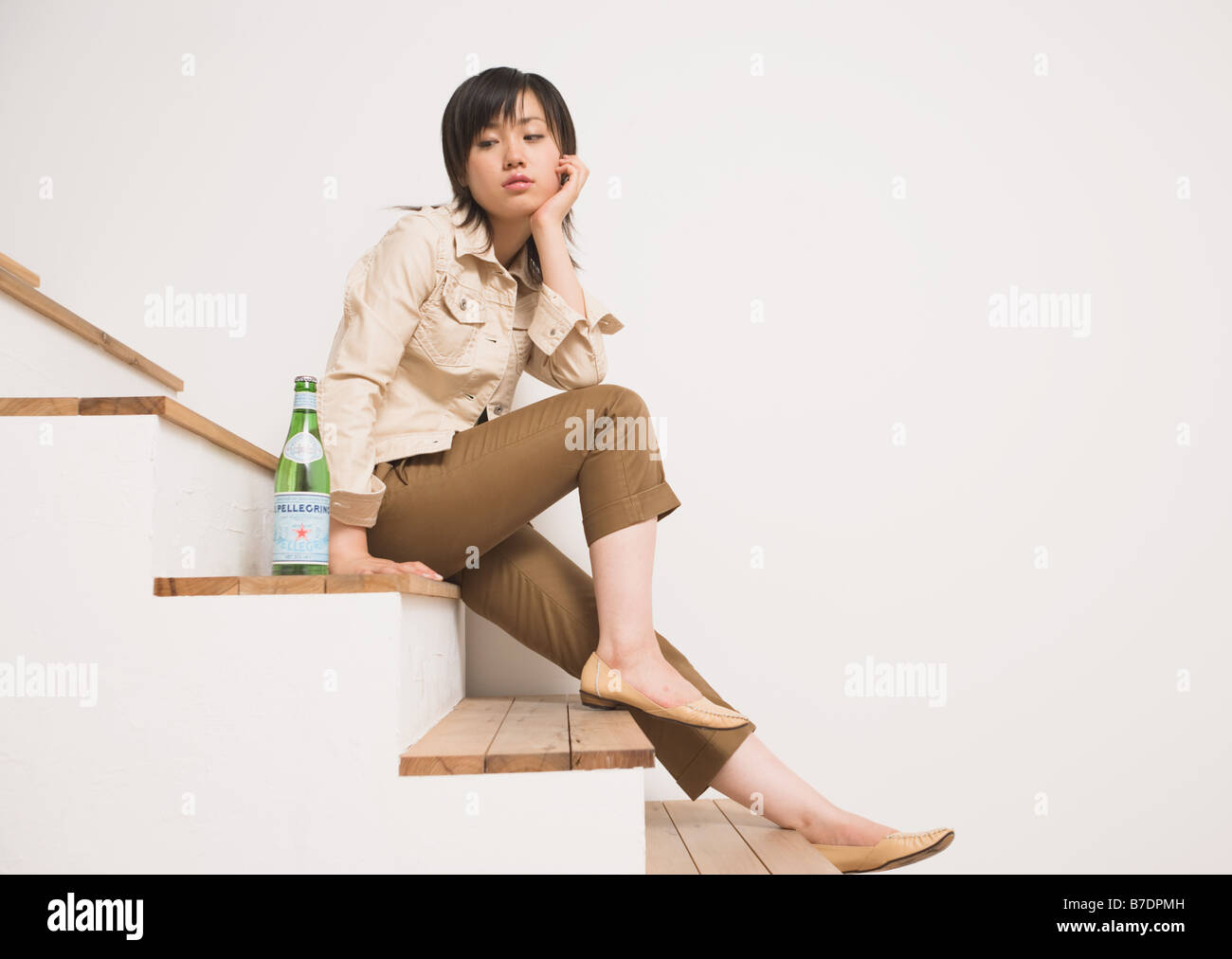 Young woman sitting on stairs Stock Photo - Alamy