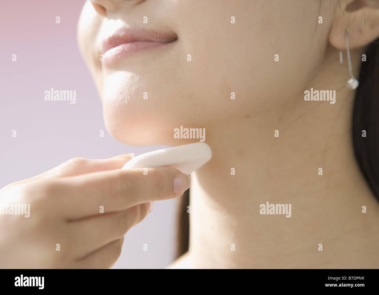 Woman applying powder with puff Stock Photo - Alamy