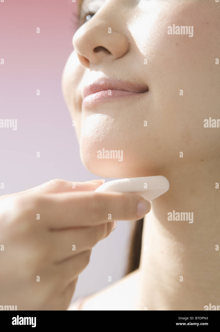 Woman applying powder with puff Stock Photo - Alamy