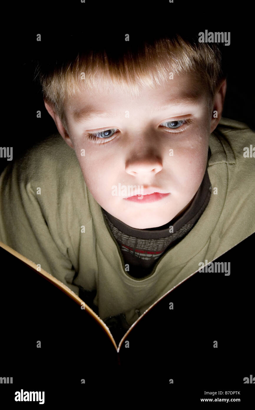 young boy reading in bed by torchlight Stock Photo - Alamy