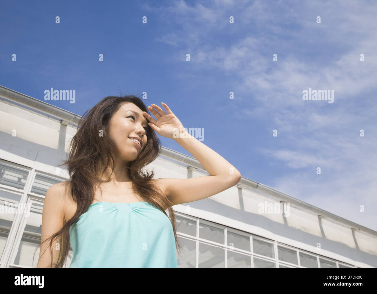 Woman with long hair looking away Stock Photo - Alamy