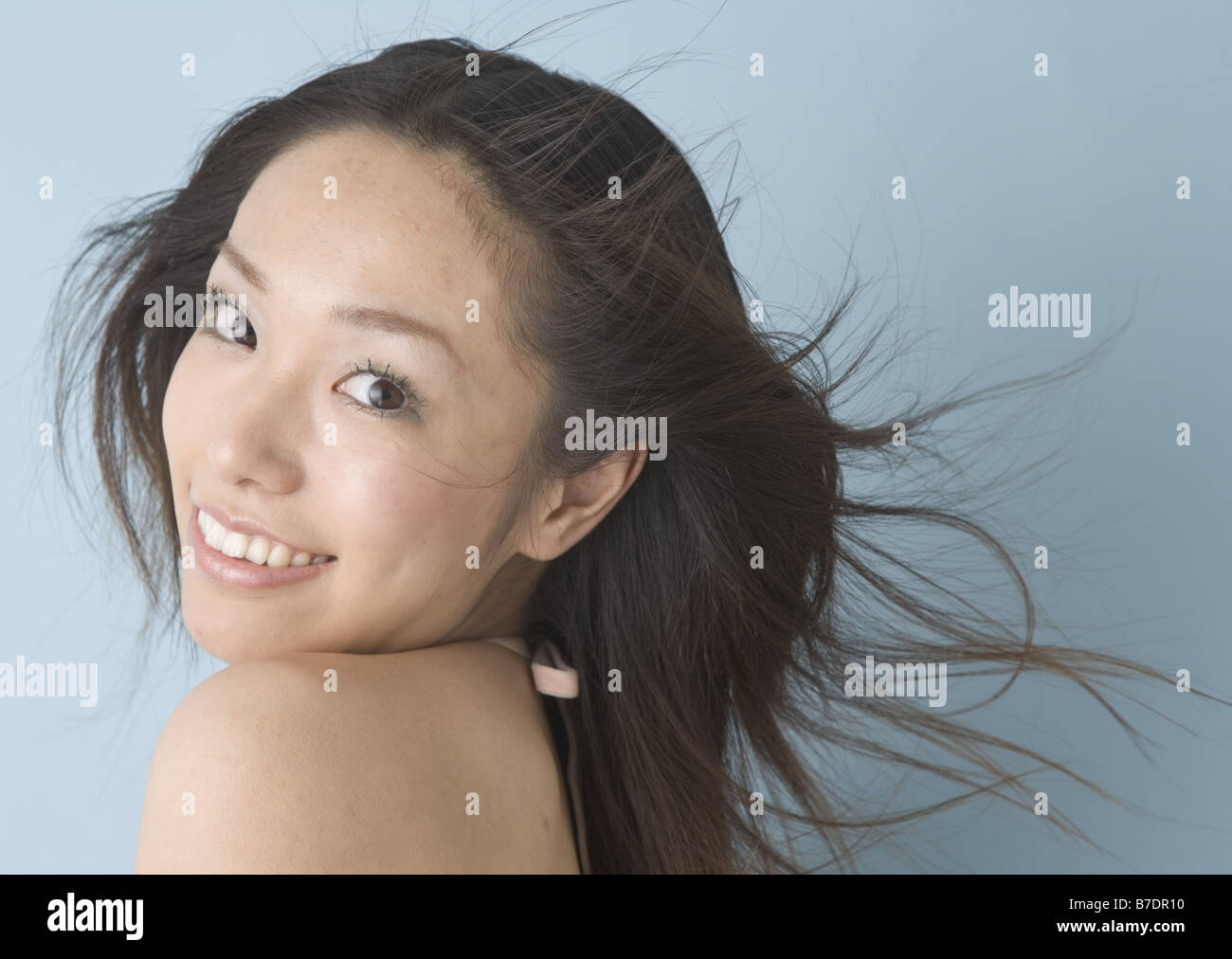 Young woman looking over shoulder Stock Photo - Alamy