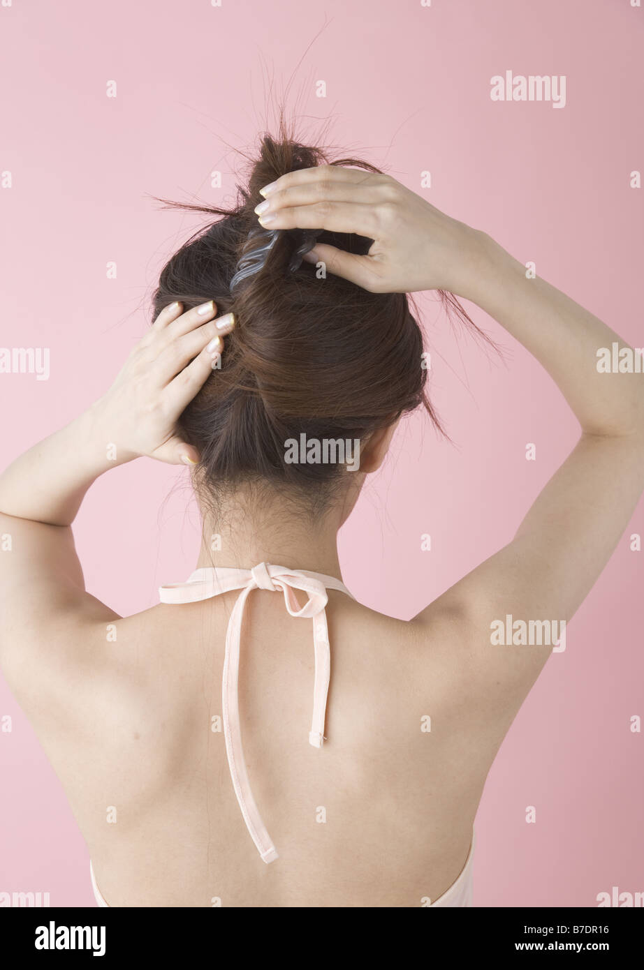 Rear view of woman pulling hair back Stock Photo - Alamy