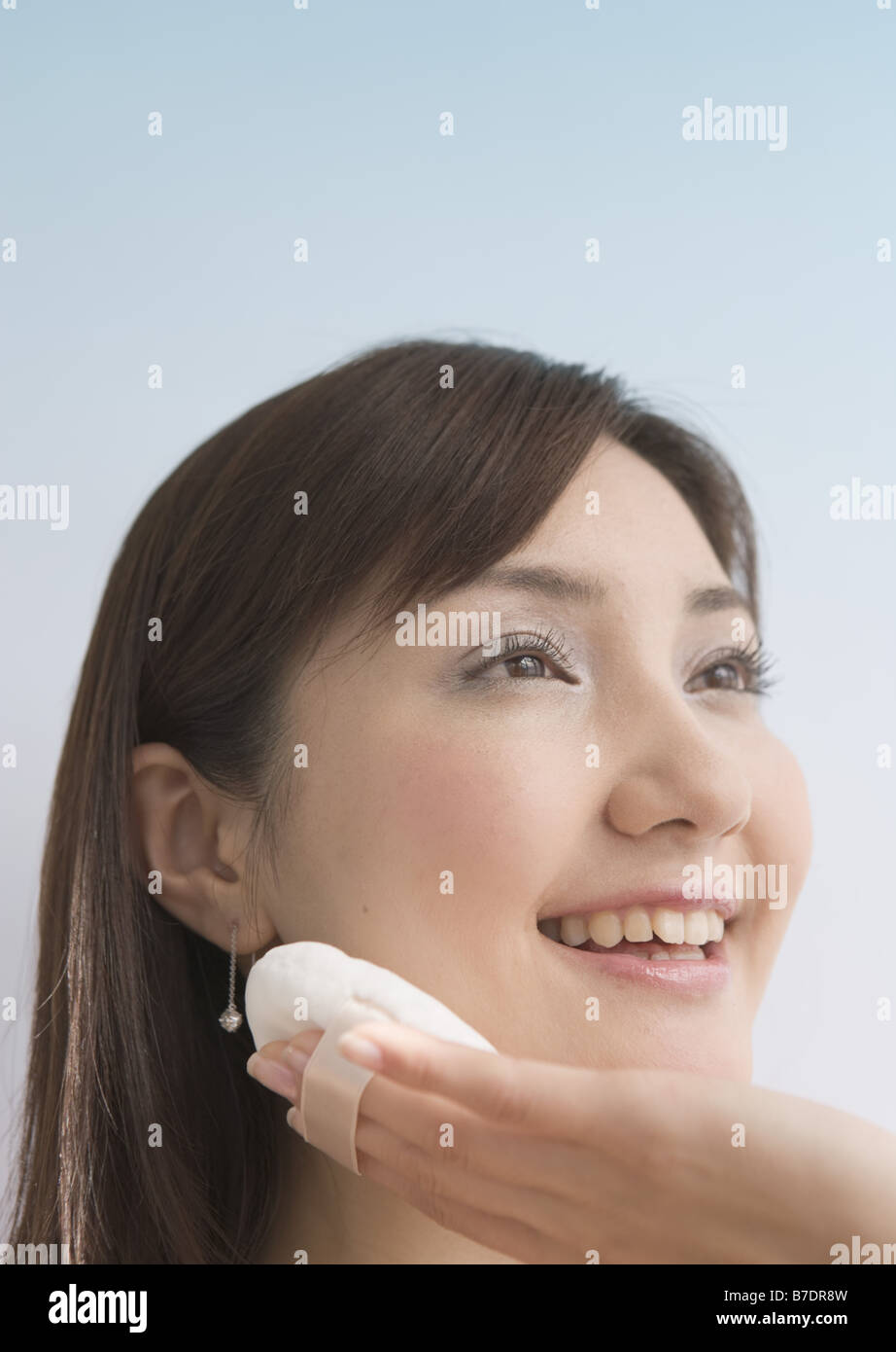 Woman applying powder with puff Stock Photo - Alamy